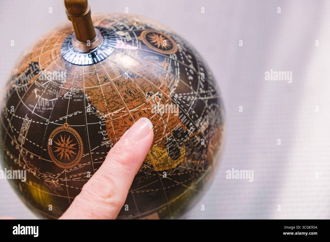 Finger pointing at vintage globe map. Hand touching world globe with ...