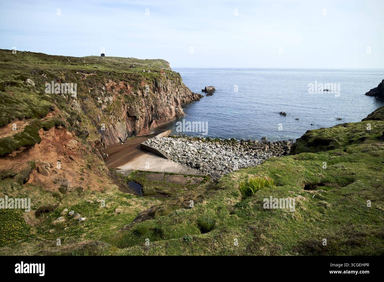 rugged worn cliff face with small inlet and slipway north west tory ...