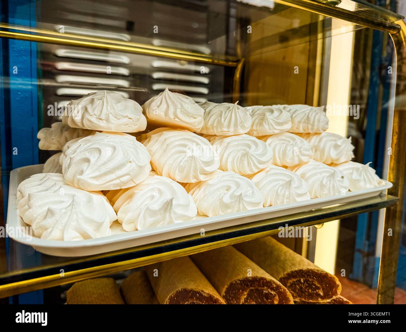 Meringue sweets displayed in bakery showcase with light airy texture ...