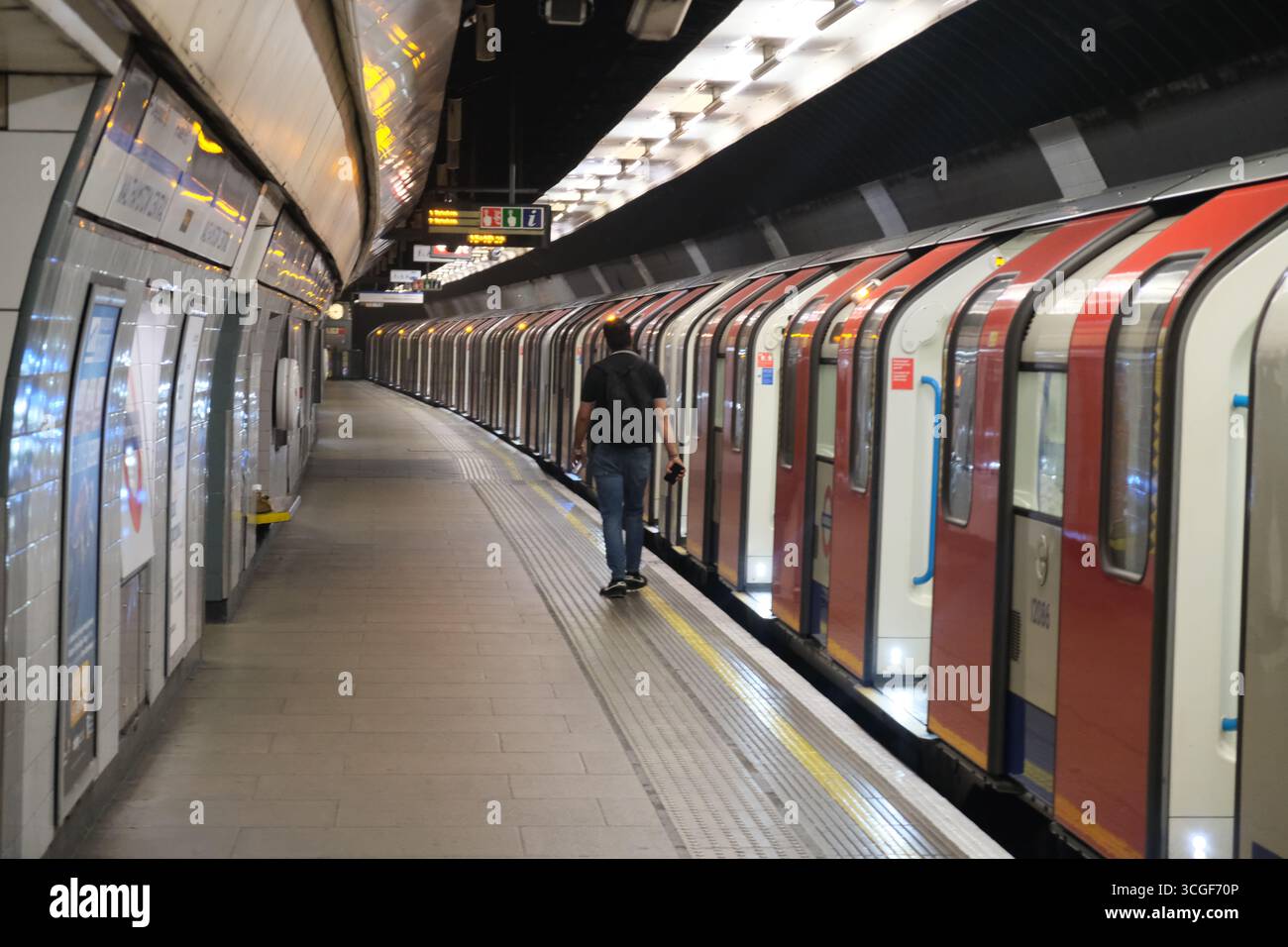 A man walks alongside a Victoria Line train at the London Underground ...