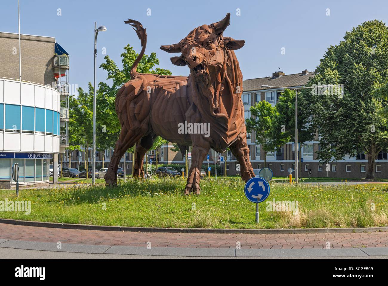 A large, rusty metal bull sculpture stands proudly on a grassy ...