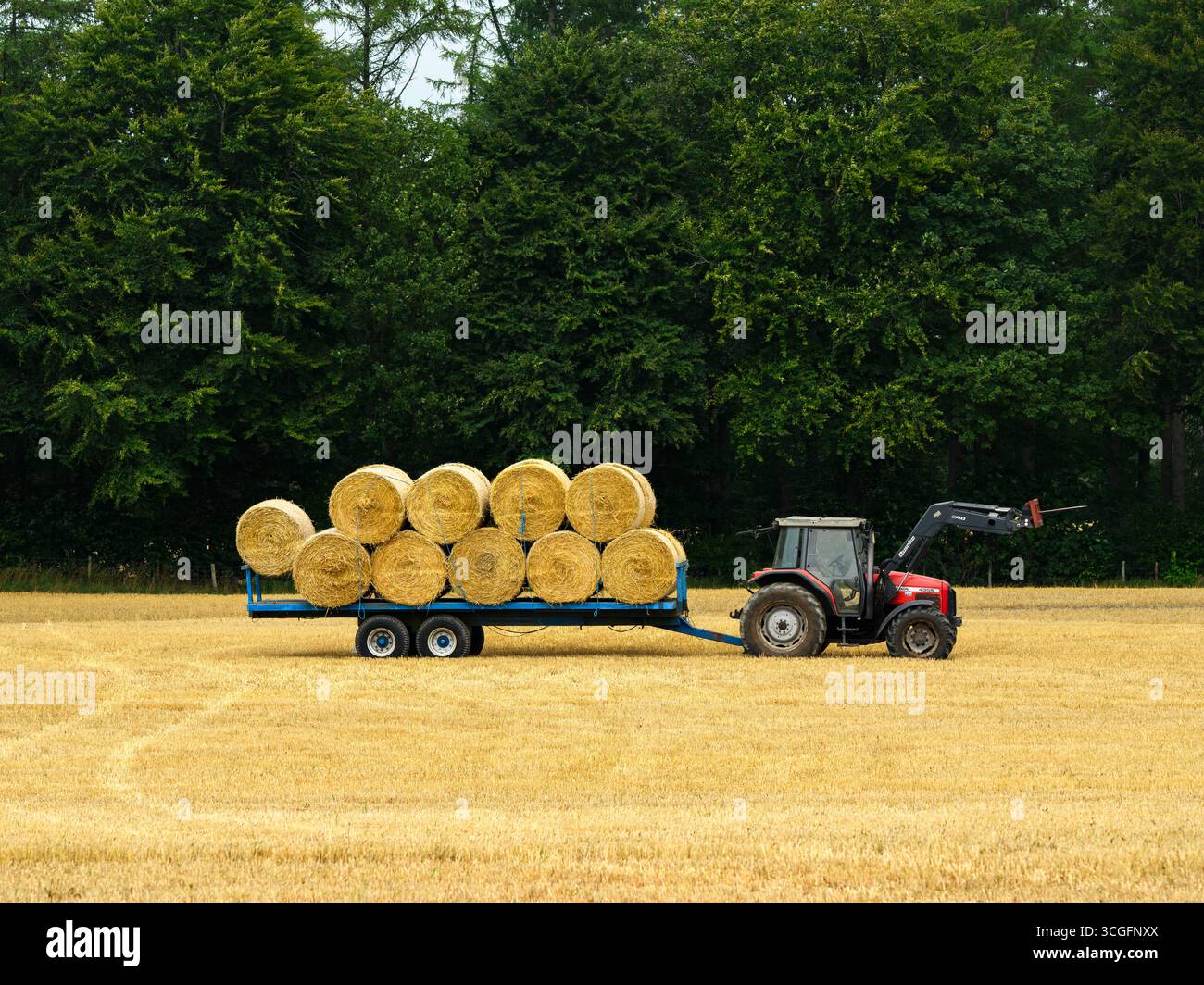 Tractor & front loader parked in field (side view). Unwrapped circular ...