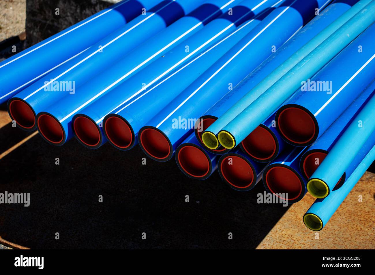 blue plastic pipe conduit laying in a pile ready for use in in ...