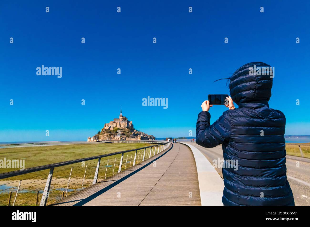 A woman is taking a photo with her mobile phone of the famous Mont ...