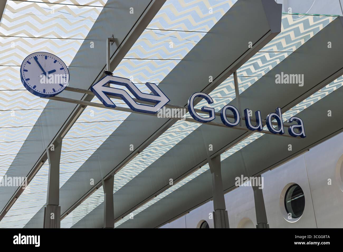 A modern train station sign for "Gouda" with the Dutch railway logo and ...