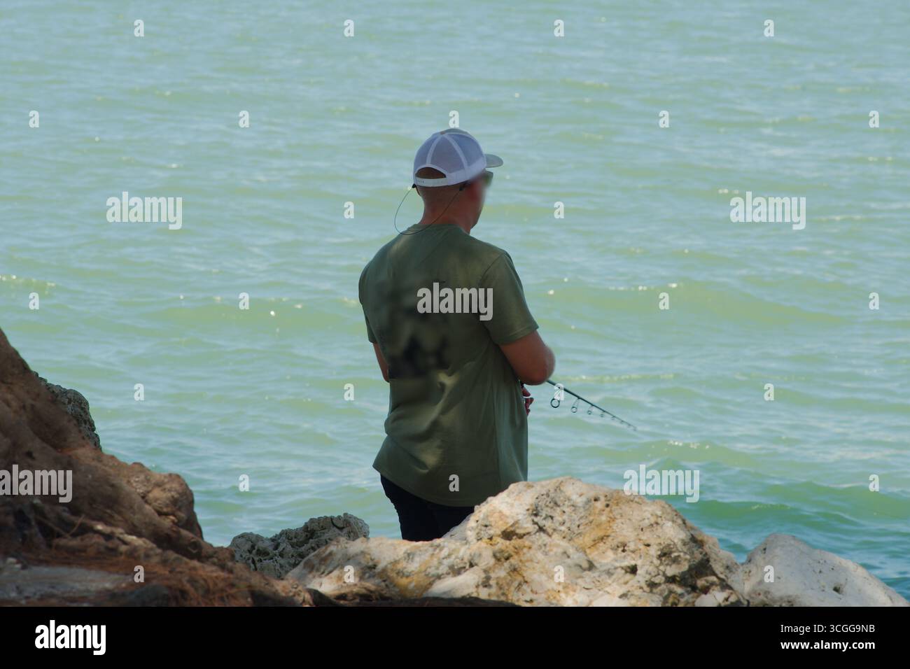 Scenic Shoreline View with one person Fishing by the Ocean. Individuals ...