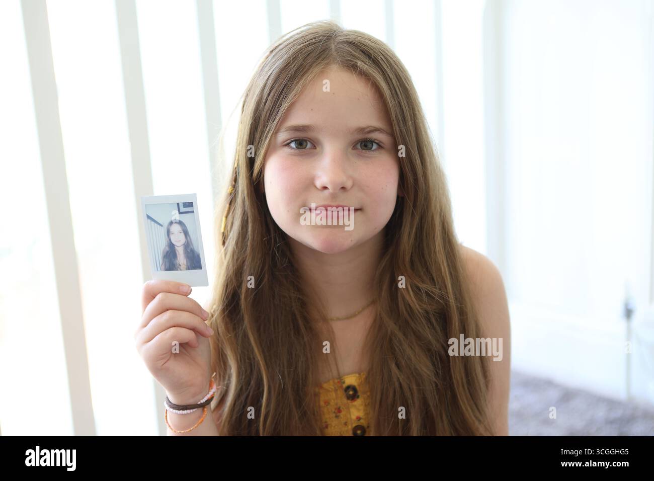 Girl holds print of herself taken on instant camera concept identity ...