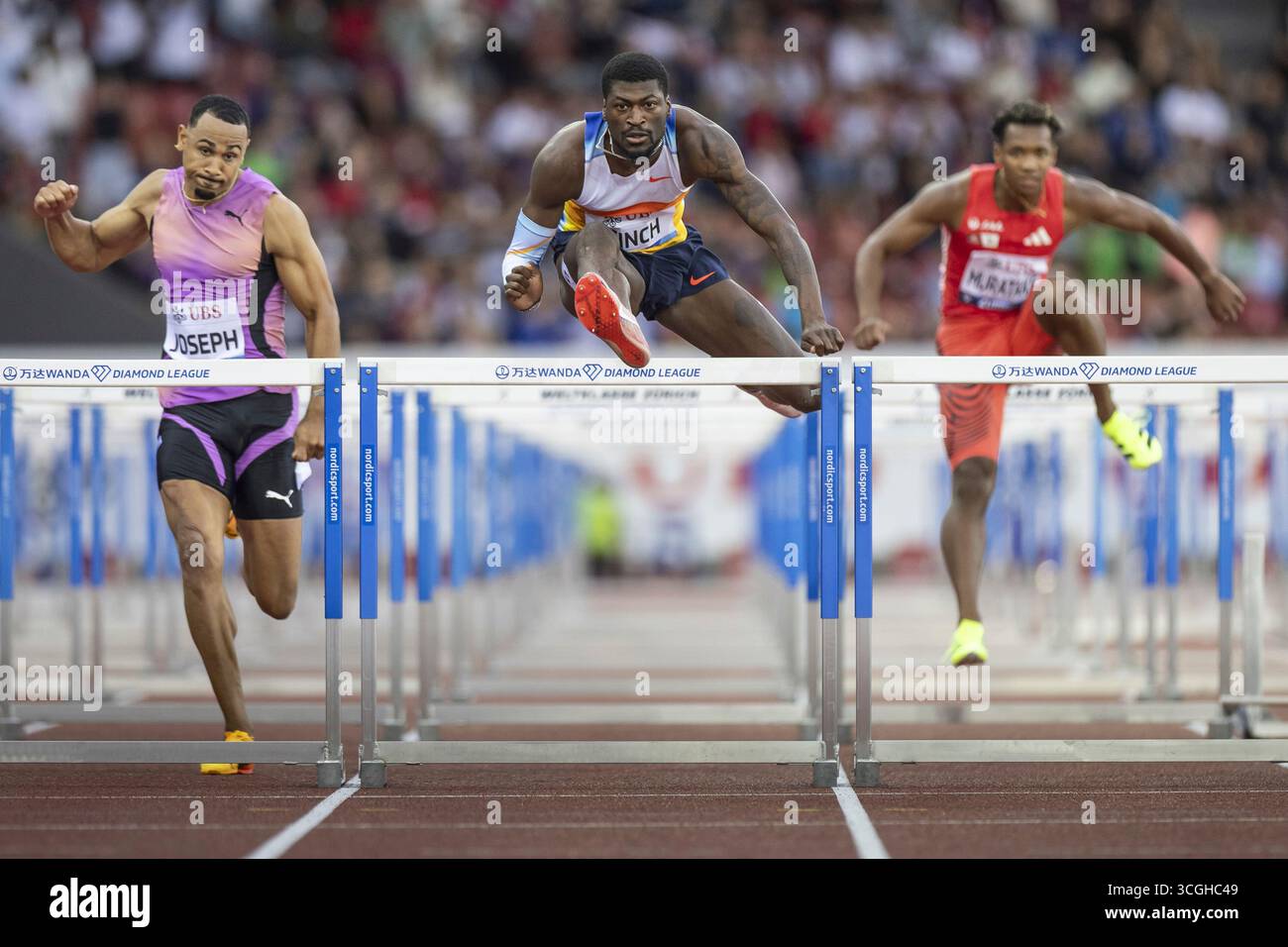 Cordell Tinch of the US, center, on his way to winning the men's 110m ...