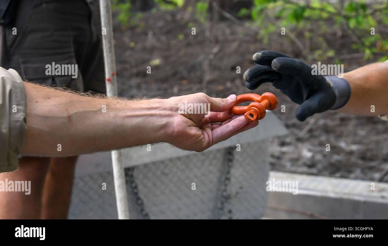 A shackle being handed over, used to secure the warp or towing line to ...