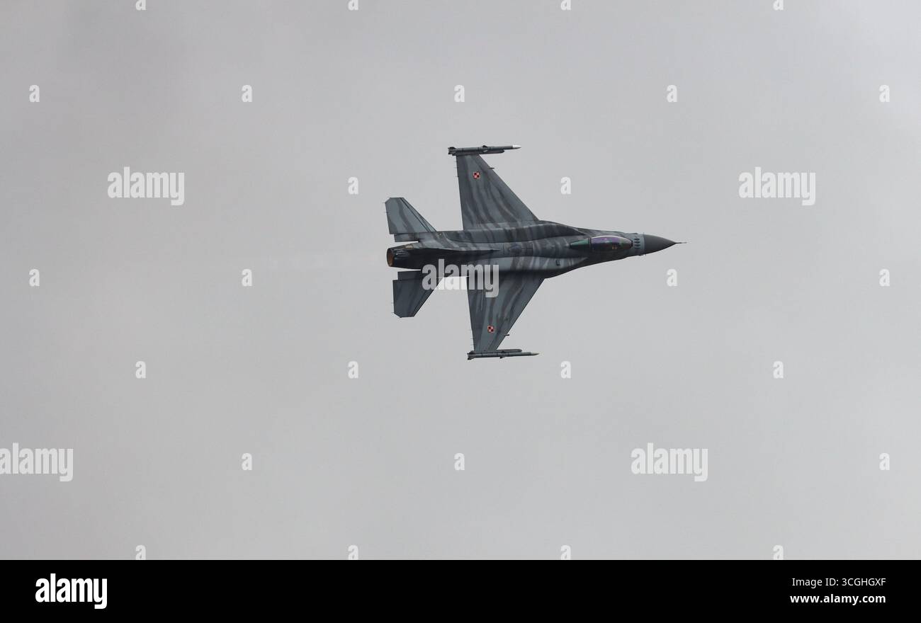 A fighter jet flying in a cloudy sky, showcasing sleek design and ...
