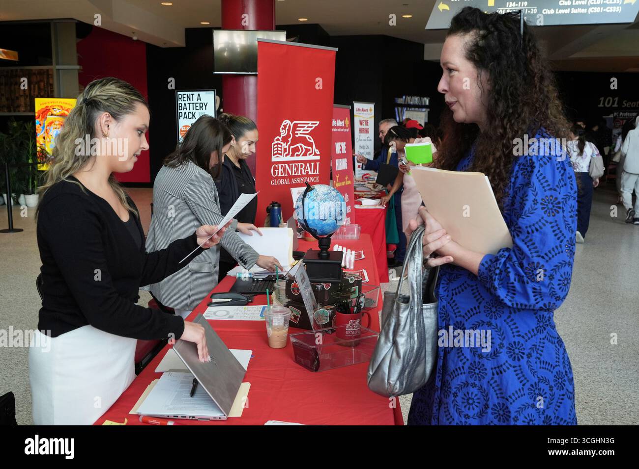 Kaylee Lanier, a recruiter for General Global Assistance, looks over ...