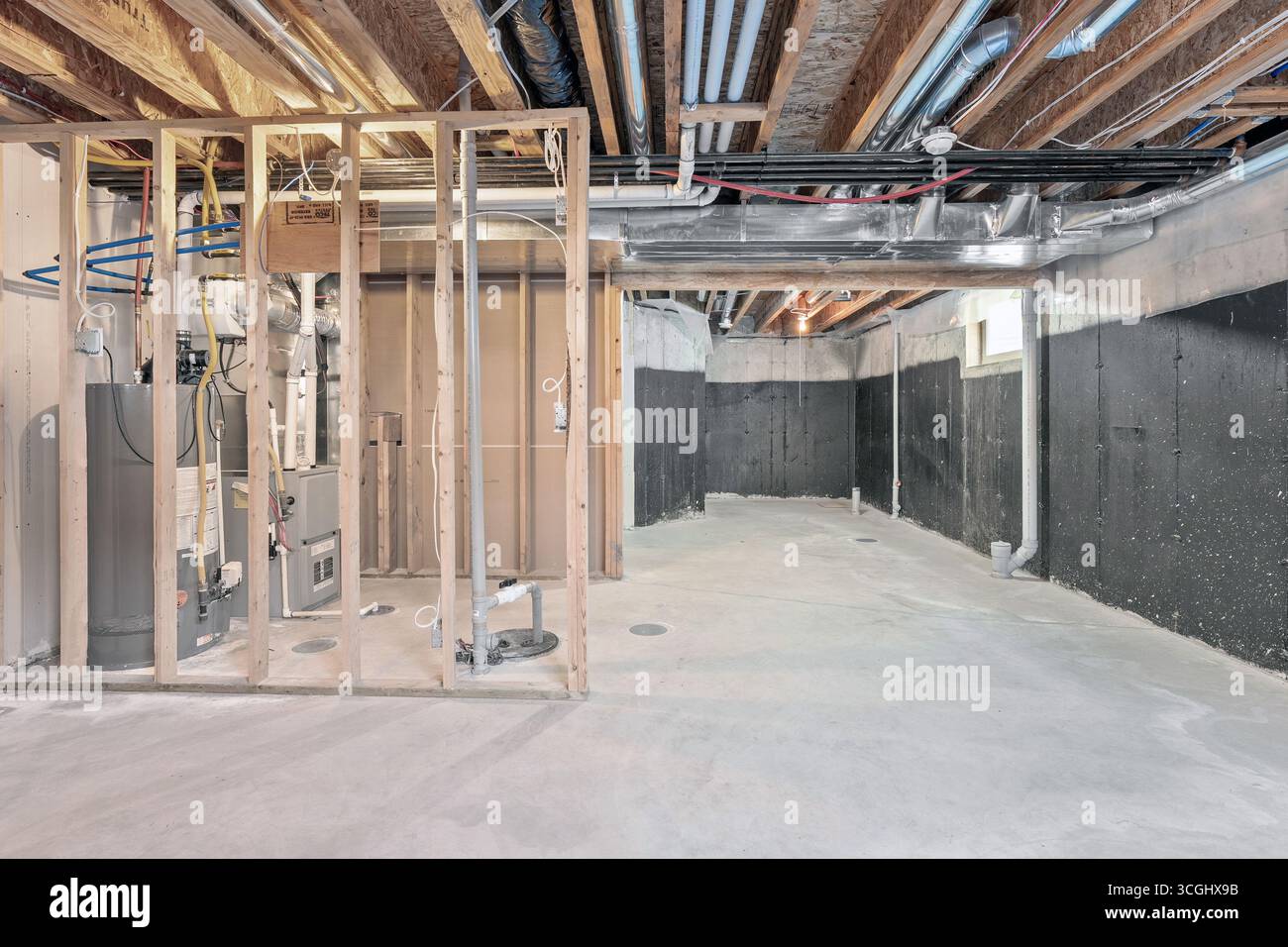 Large unfinished basement with a lot of exposed pipes and a lot of ...