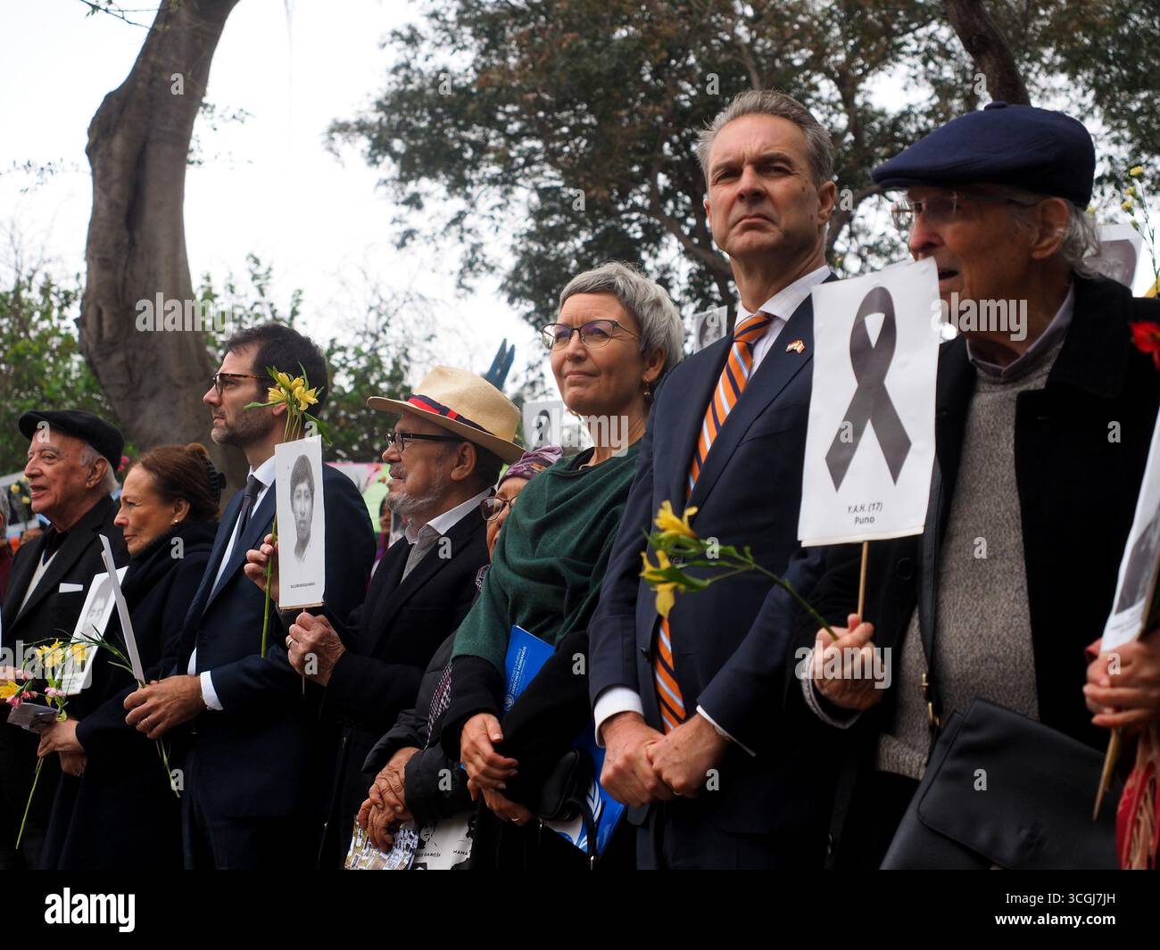 People holding photographs of the victims in the commemoration ceremony ...
