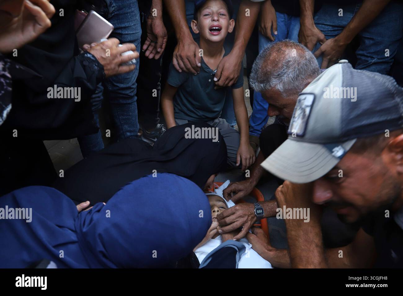 Palestinian relatives mourn over the body of 13-year-old Karim Qdeih ...