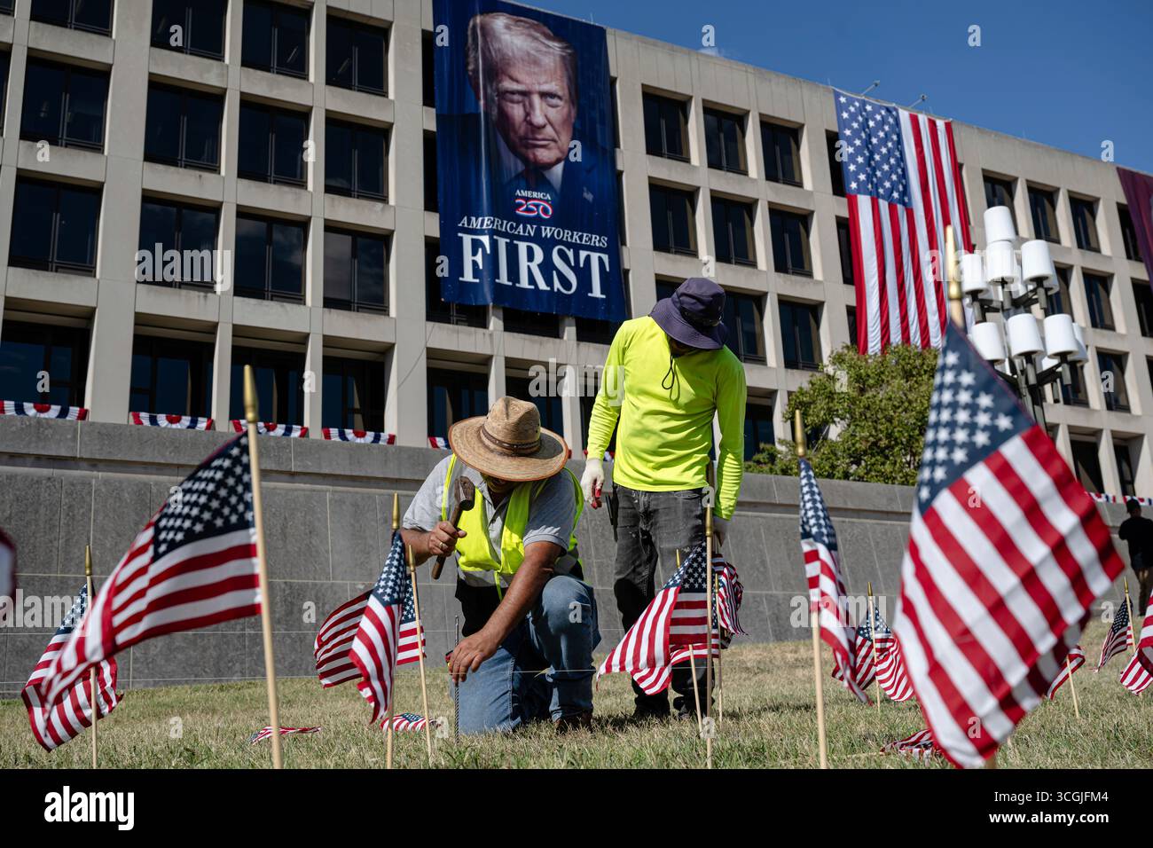 Workers plant American flags on the lawn of the US Department of Labor ...