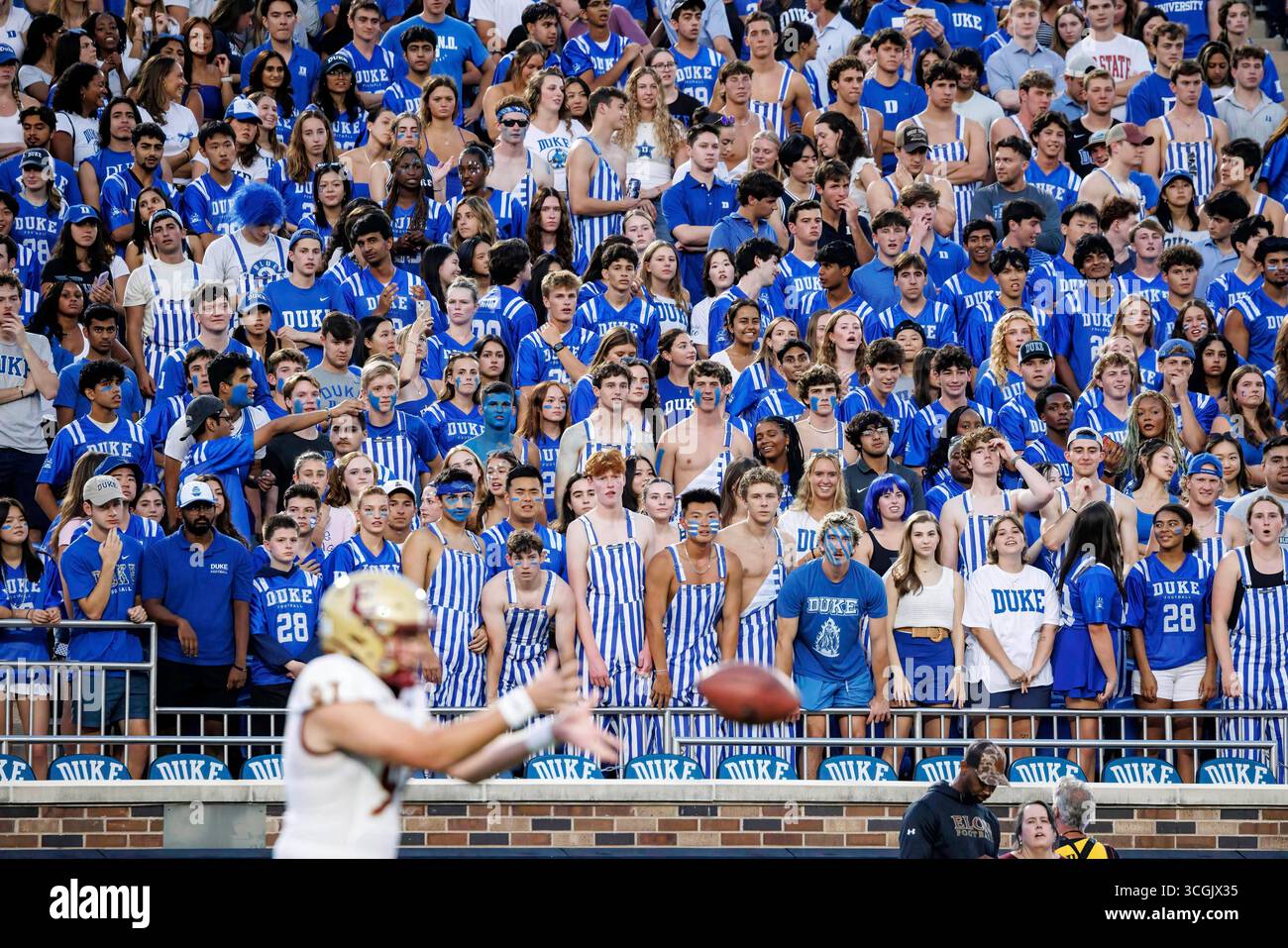 Duke fans, background, watch as Elon's Jeff Yurk, foreground, waits for ...