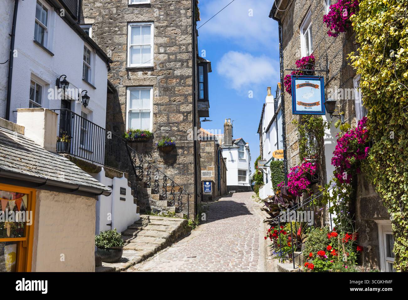 St Ives Cornwall cobbled street with white cottages and granite walls ...