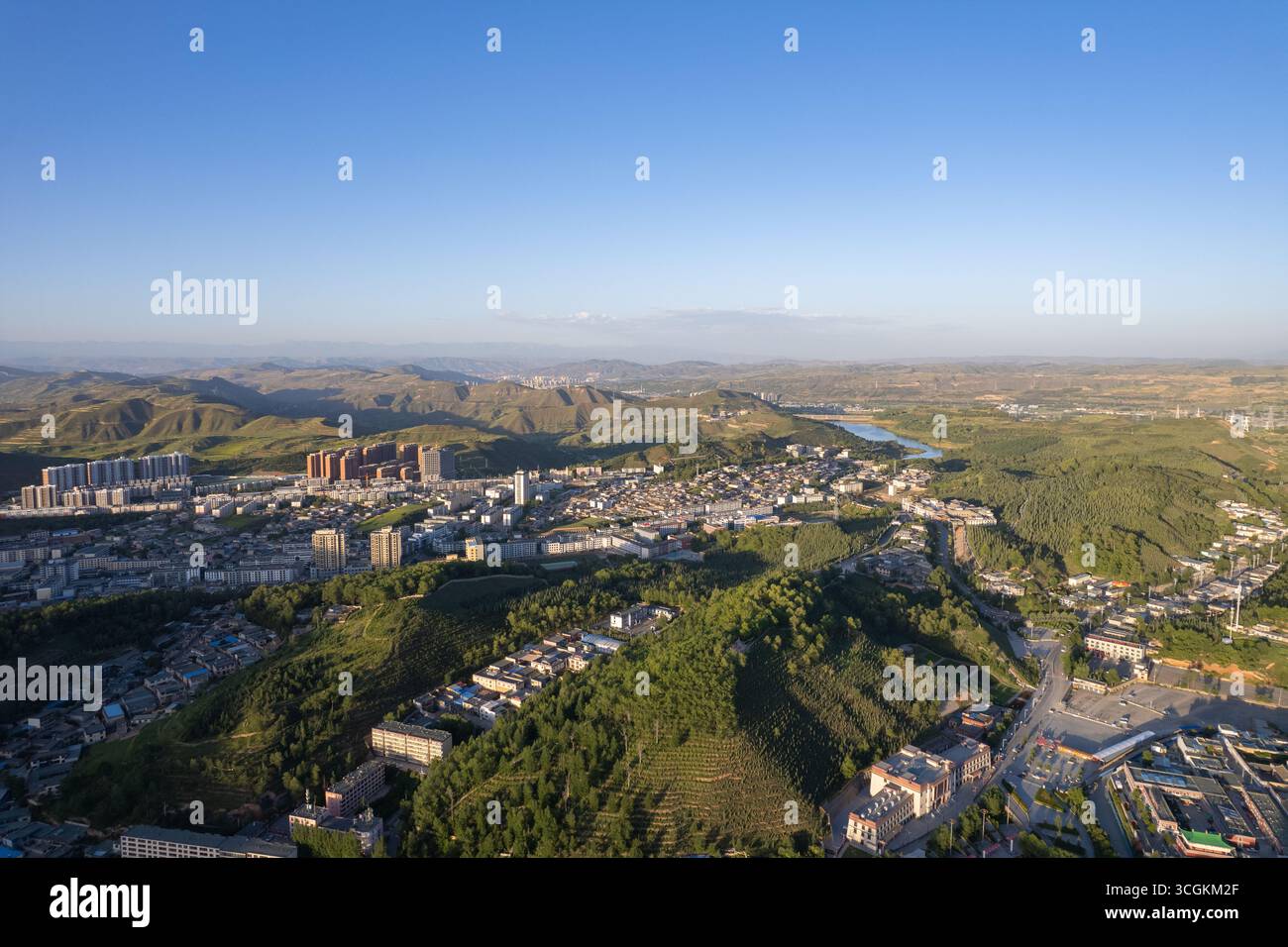 An aerial view shows city, green hills, and distant lake, a wide travel ...
