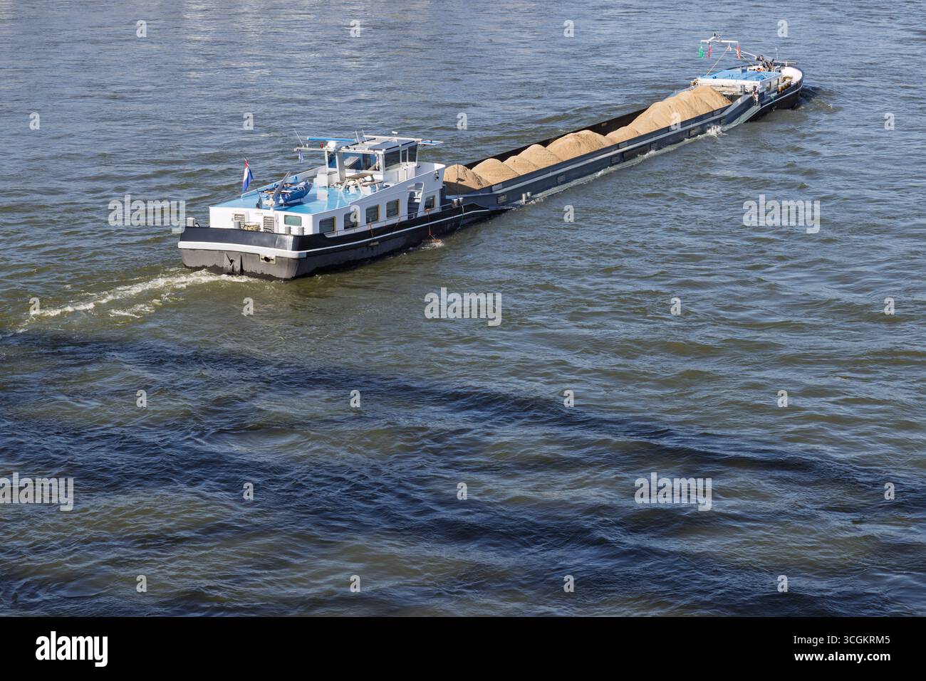 A close-up of the cargo barge with a full load of sand or gravel ...