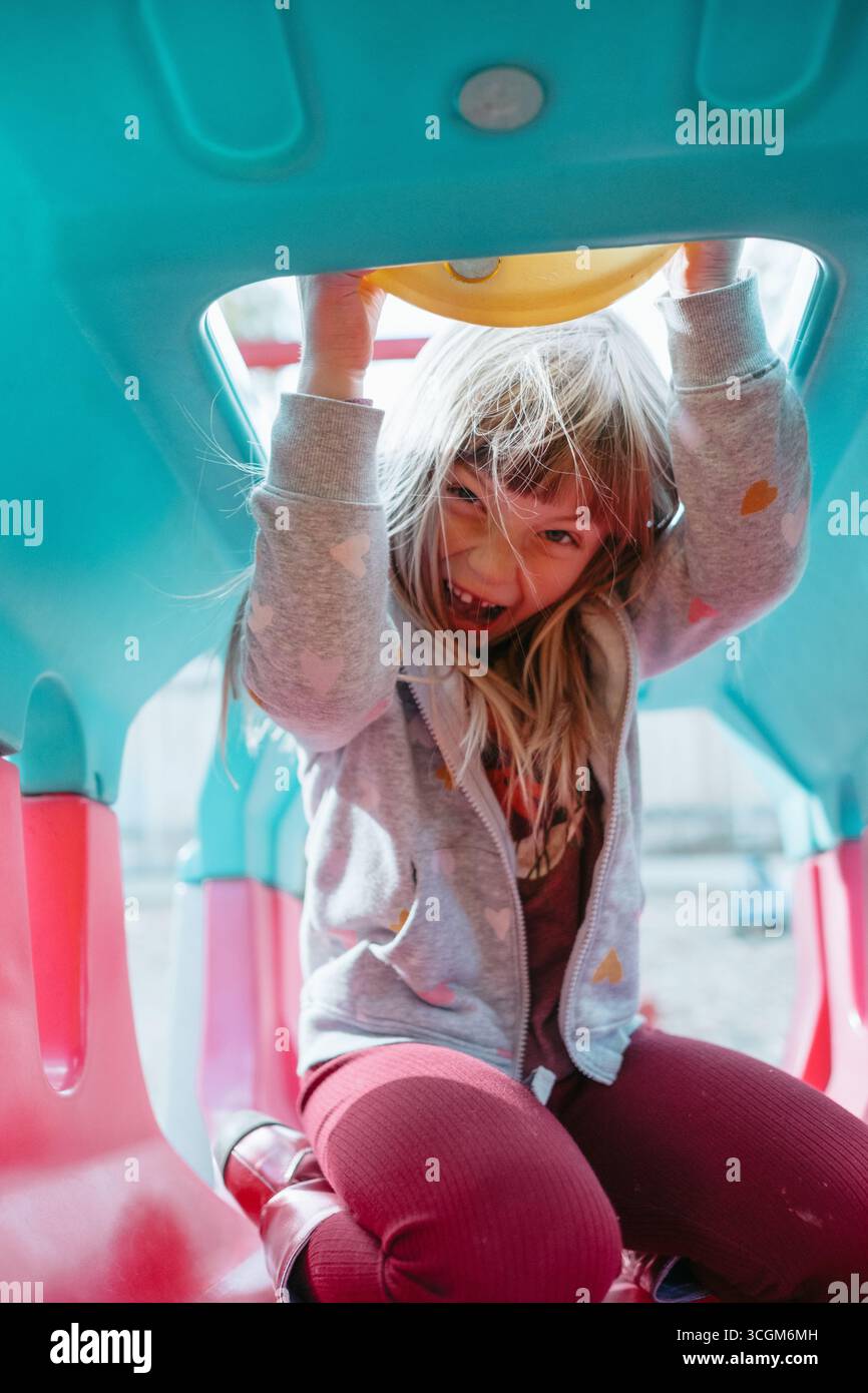 Preschool girl playing on colorful playground structure Stock Photo - Alamy