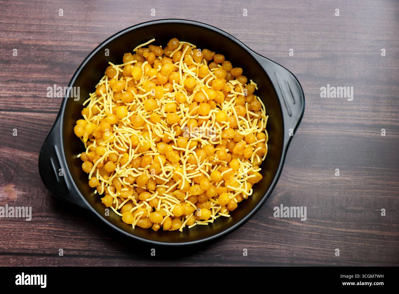 A close up of traditional Indian snacks. crispy savory sev and sweet ...