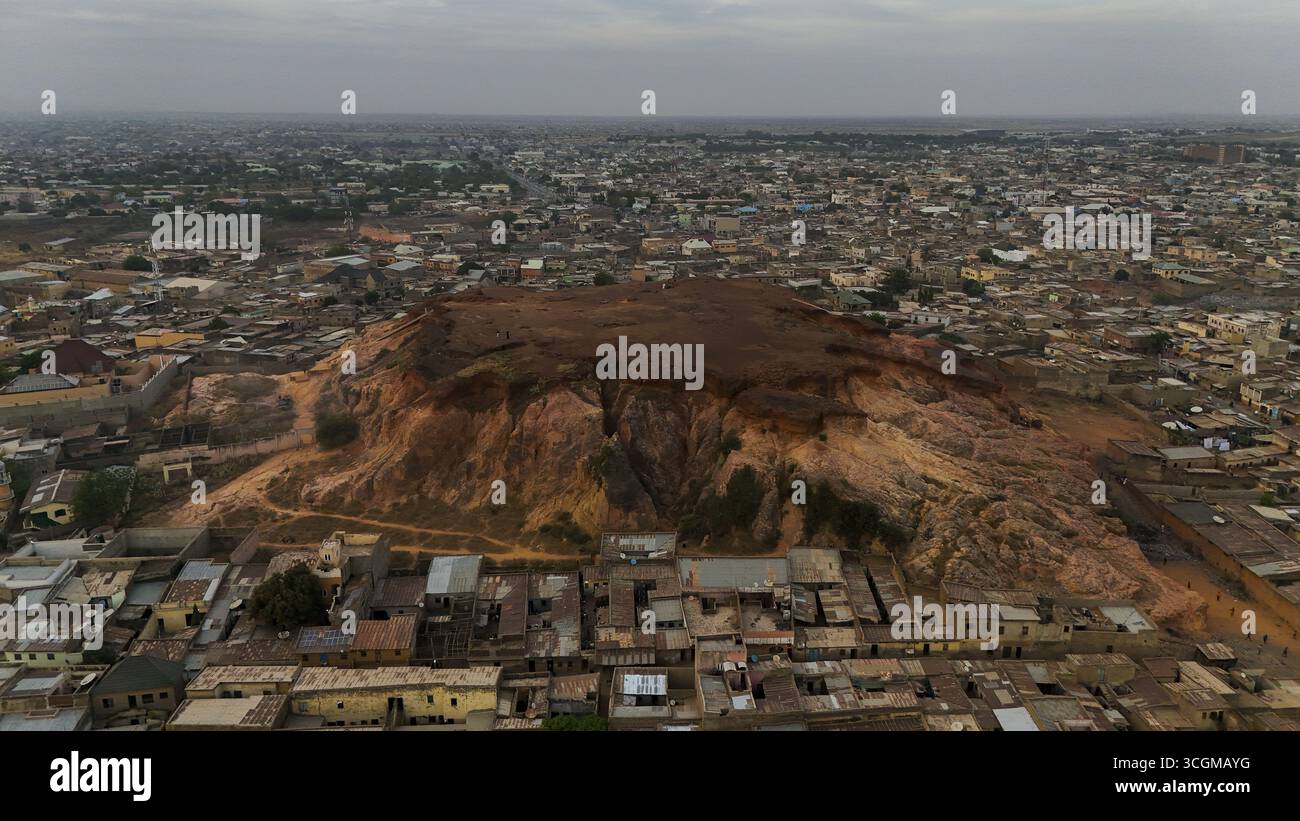 Aerial view of a large, reddish-brown rocky hill rising amidst the ...
