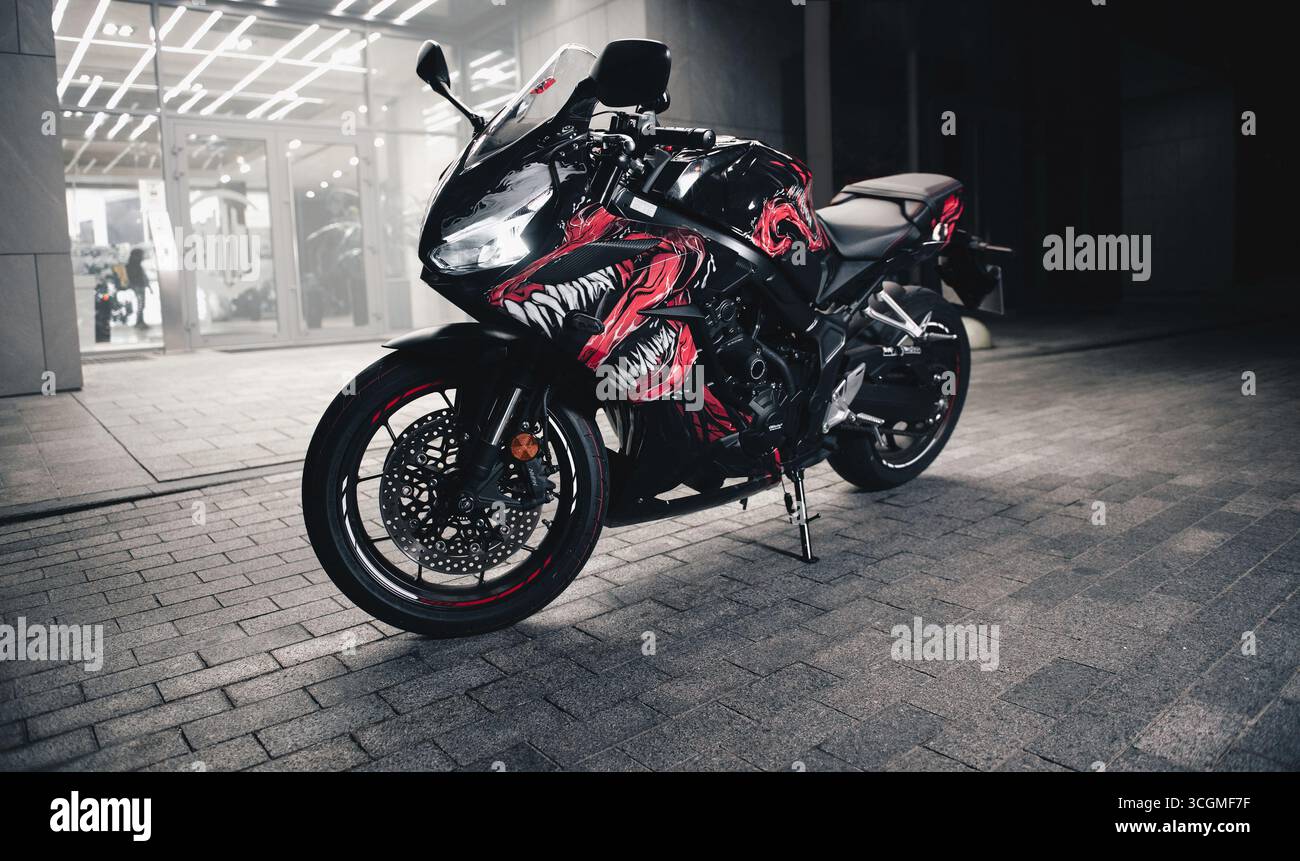Sportbike on city street at night. Three quarter front view of Honda ...