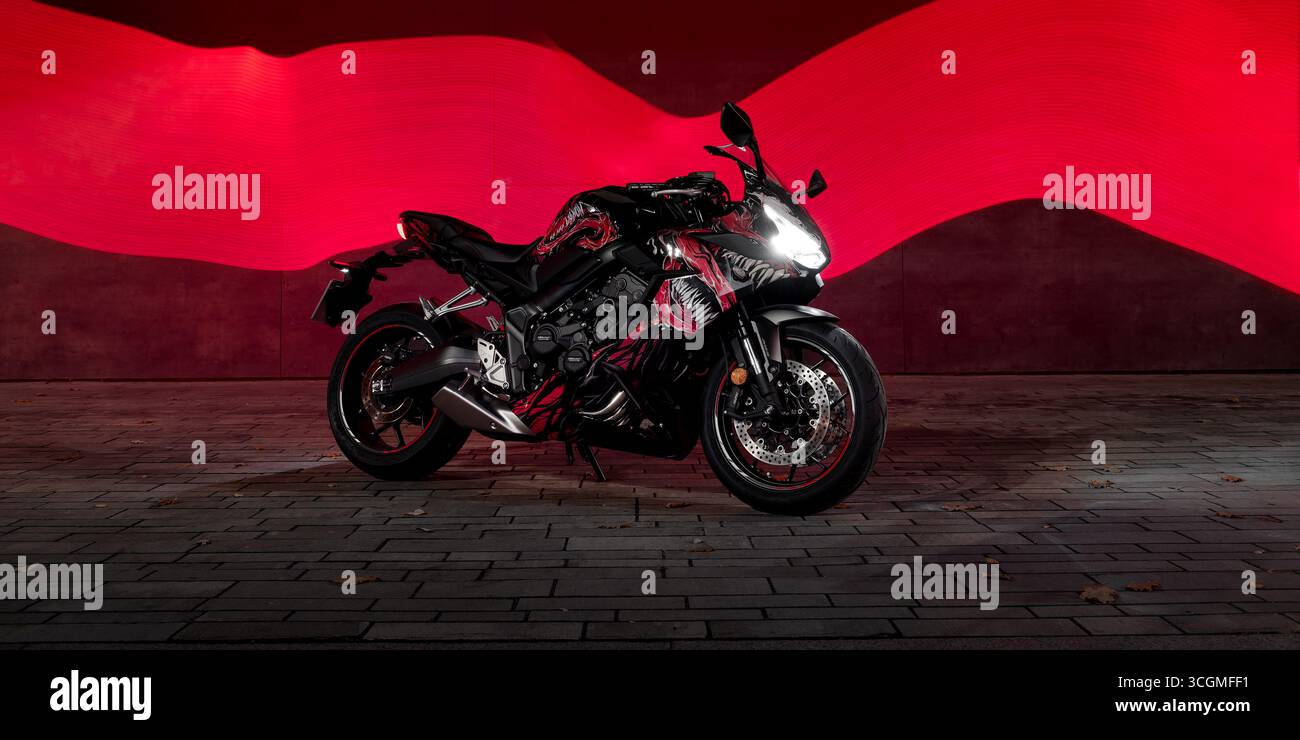 Sportbike on a street at night with red light trail behind it. Long ...