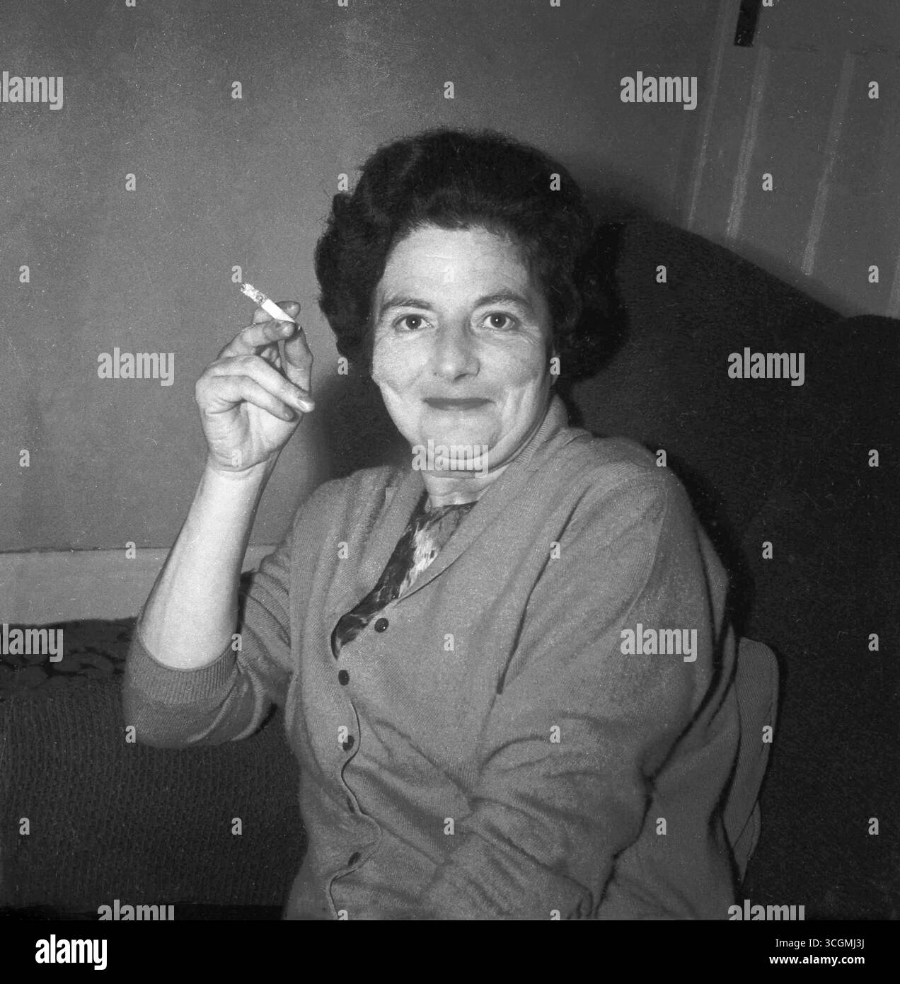 1960s, historical, a mature lady sitting for her photo looking at the ...
