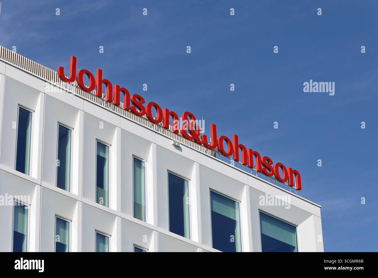 The striking red "Johnson & Johnson" logo atop a modern white building ...