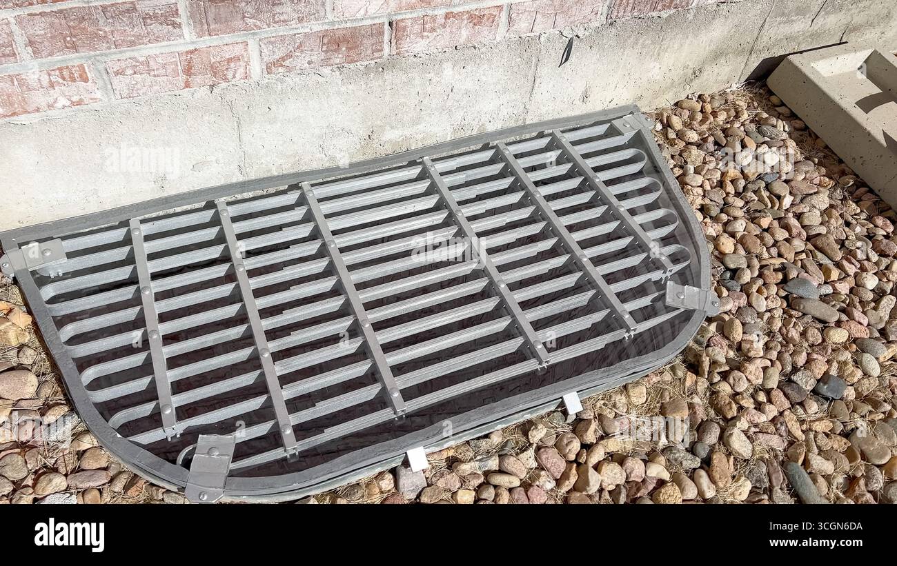 Angled view of window well grate Stock Photo - Alamy