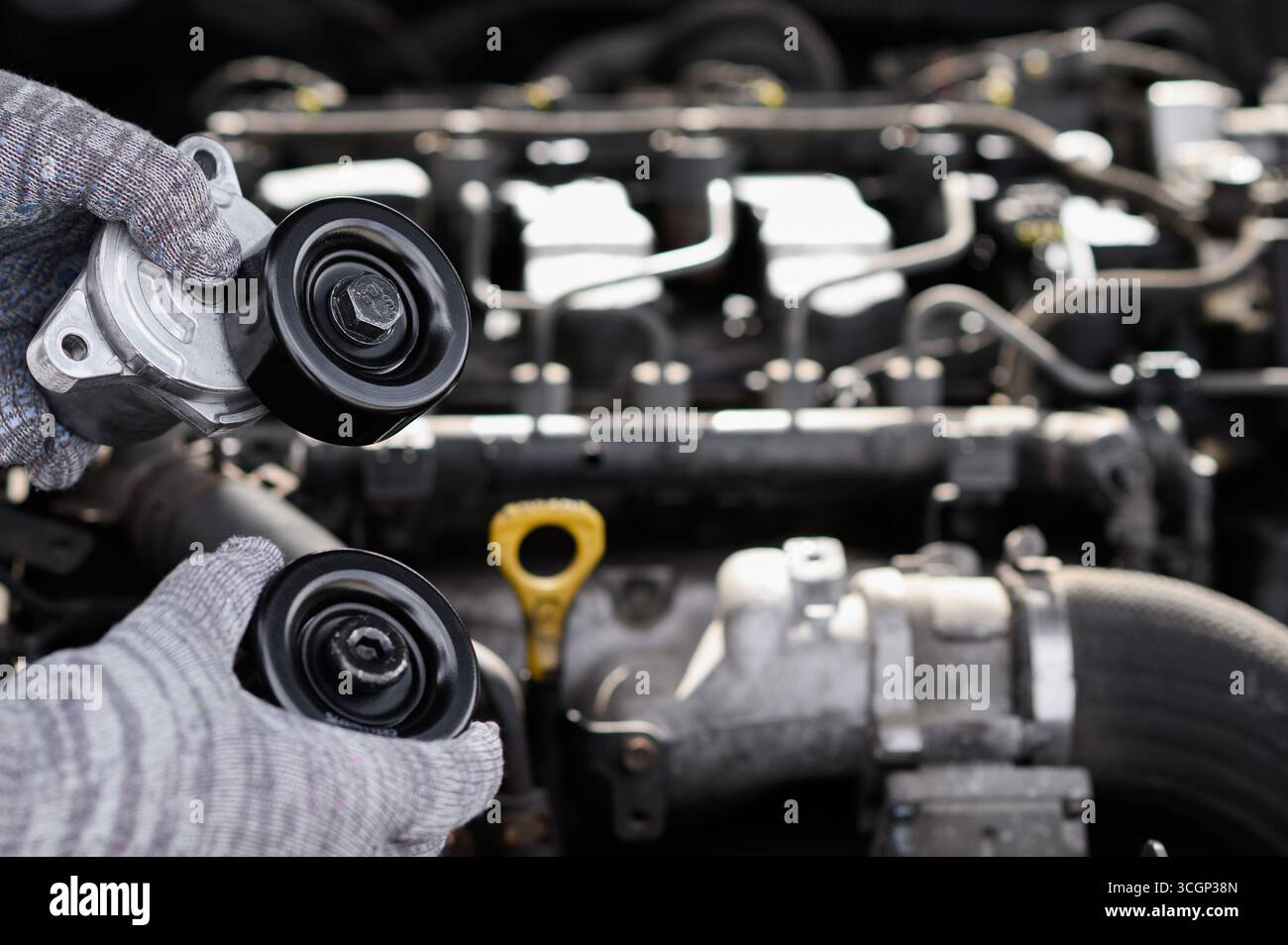 Auto mechanic holds tension and idler pulley for drive aggregate multi ...