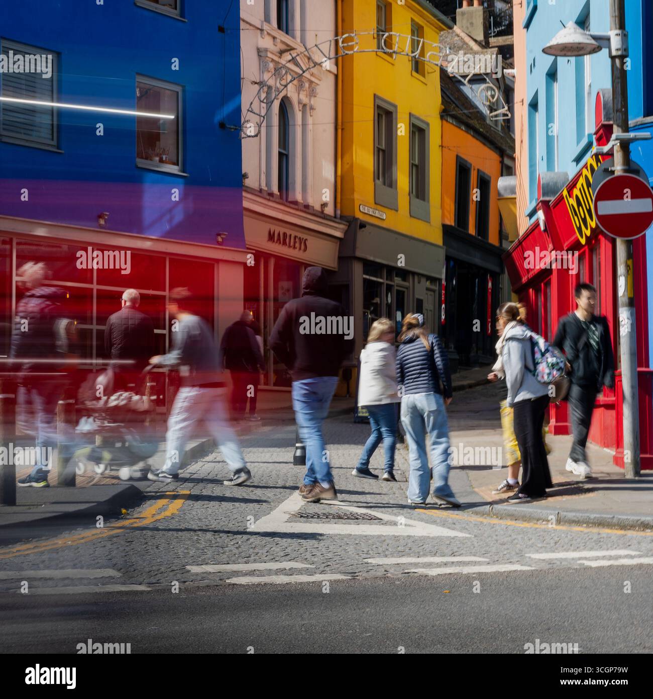 Vibrant street scene with colourful buildings and pedestrians in motion ...