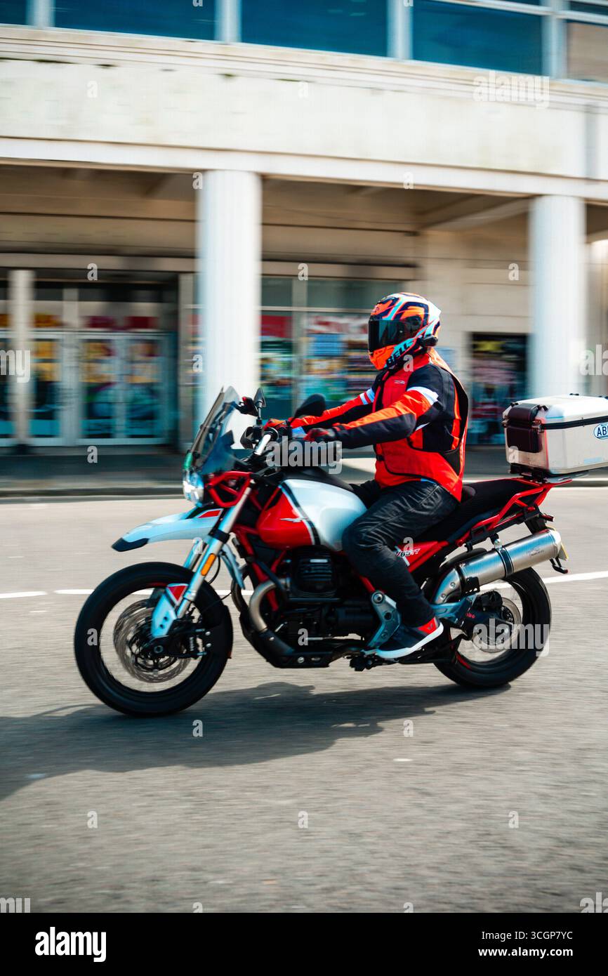 Motorcycle in red and silver with rider in helmet and jacket, motion ...