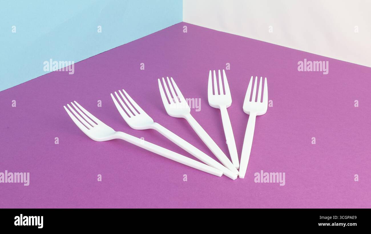 Plastic forks and abstract still life with white forks on a purple ...