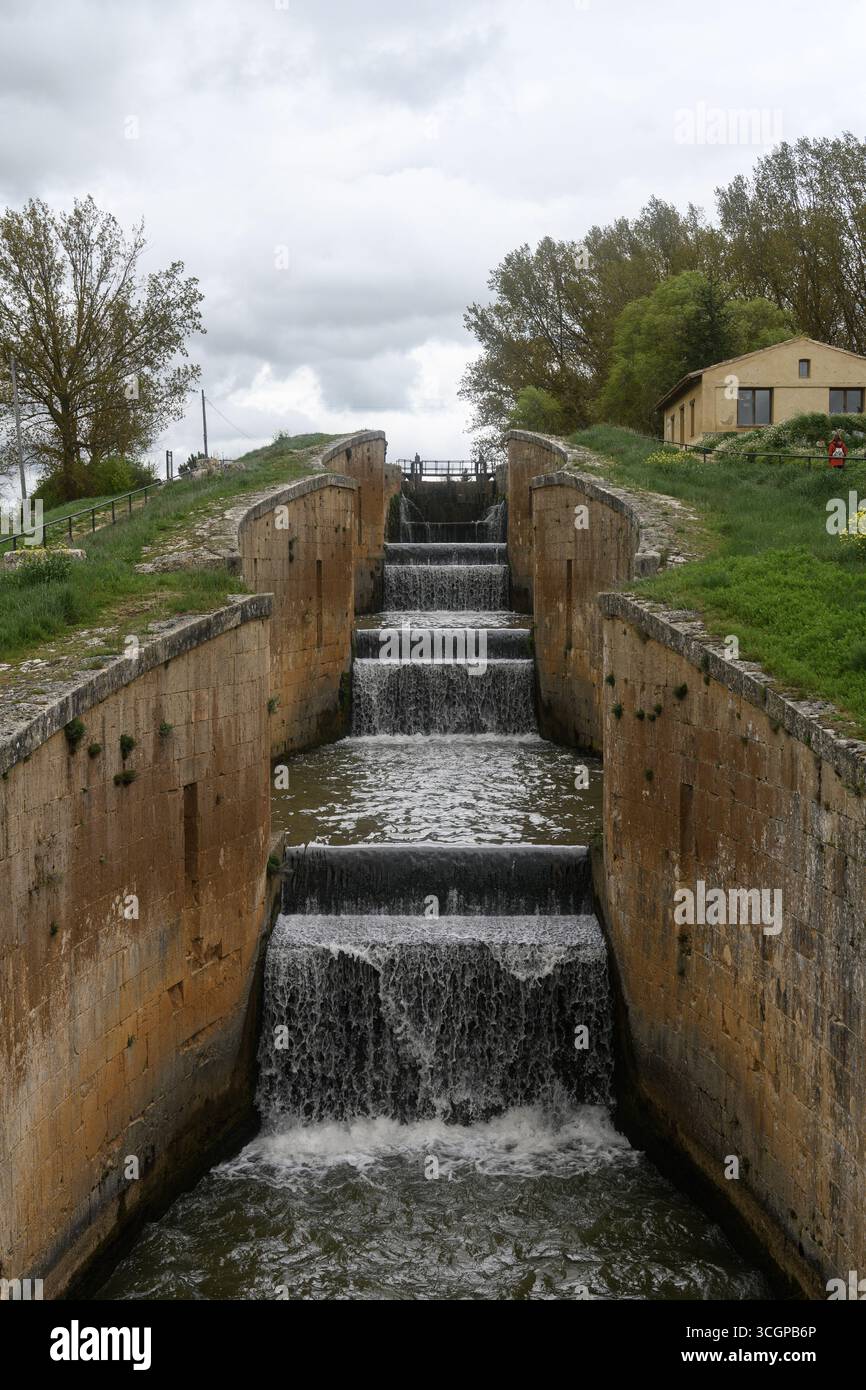 Old four-step stone lock with flowing water on the Canal de Castilla in ...