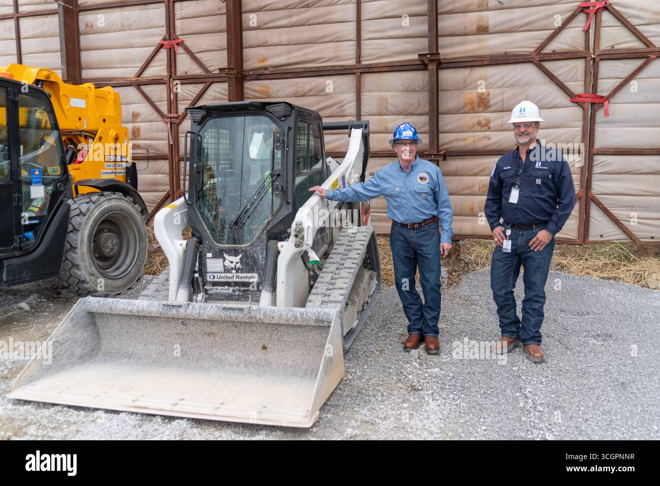 Secretary Doug Burgum stands beside heavy equipment during a site visit ...