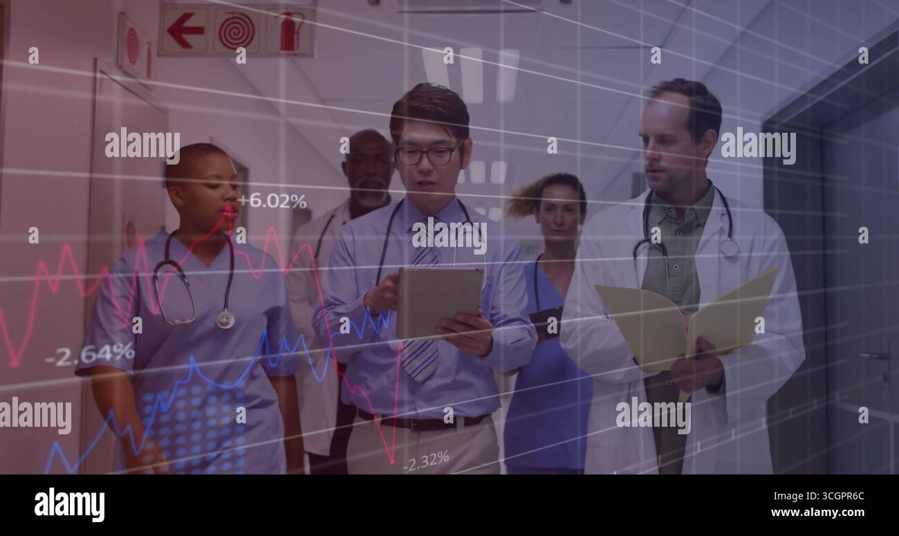 Walking medical team advancing down hospital corridor, with tablet ...
