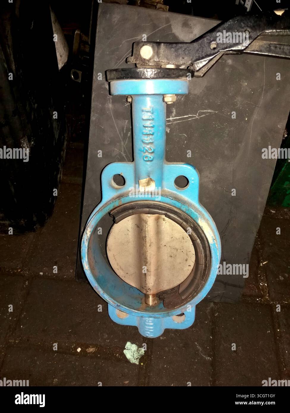 A disc valve with a visible damaged seal is shown resting on a flat ...