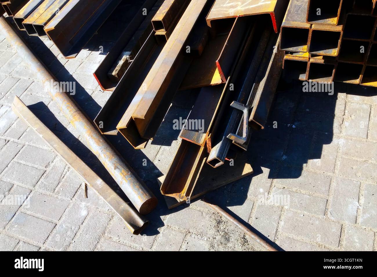 In a construction area, stacks of rolled metal lie on the ground ...