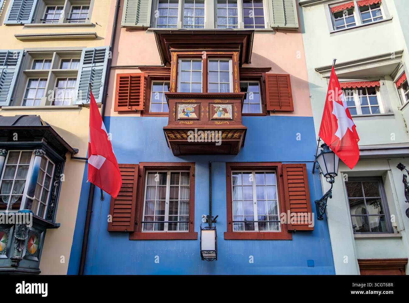 Swiss flags hang from the historic facades of traditional buildings in ...