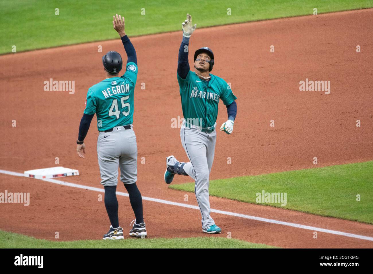 Seattle Mariners' Jorge Polanco, right, is greeted by third base coach ...