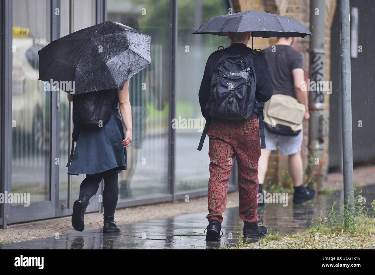 Berlin, Deutschland, 28.08.2025: Personen laufen im Regen *** Berlin ...