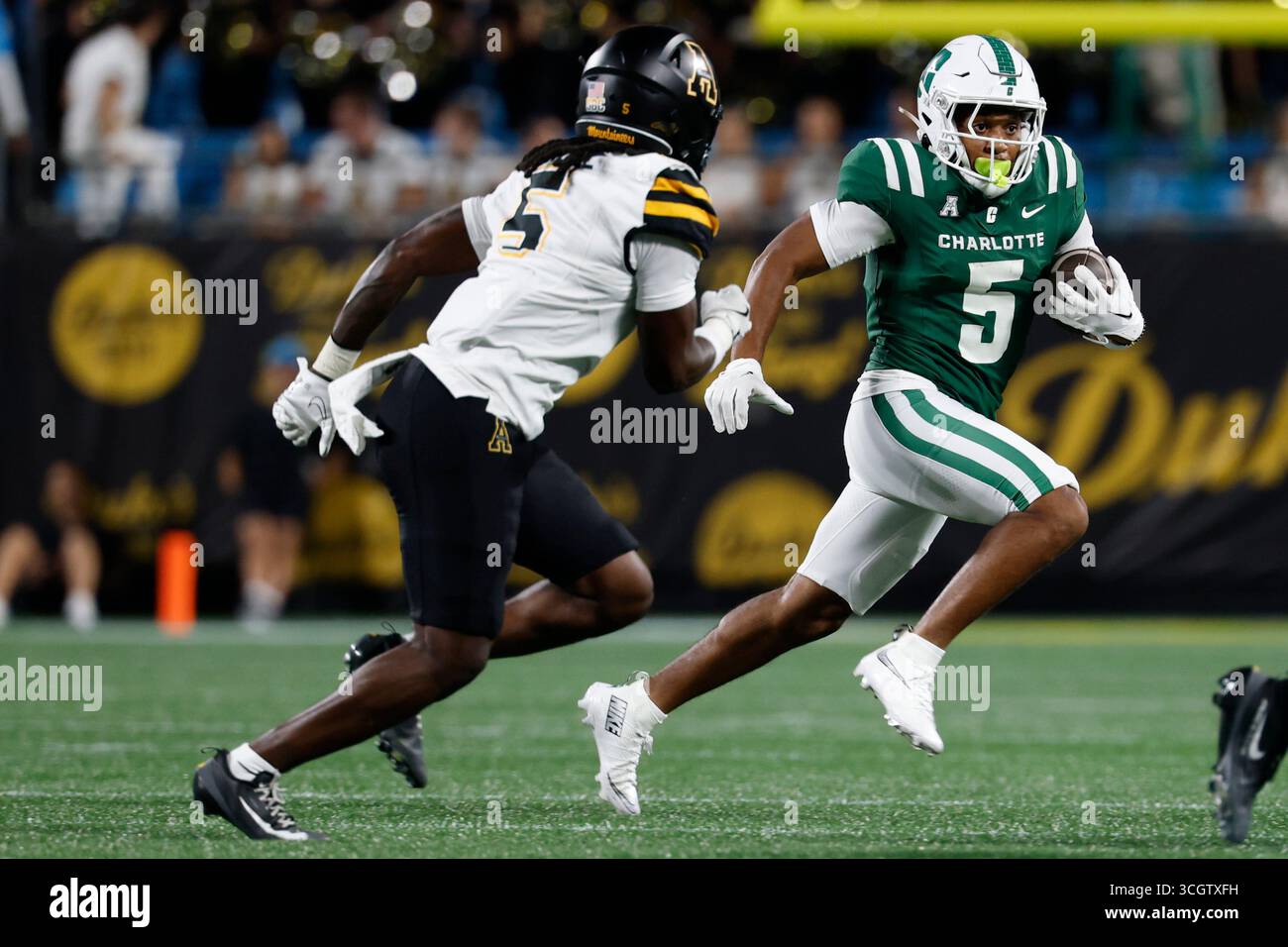 Charlotte wide receiver Javen Nicholas, right, carries the football ...