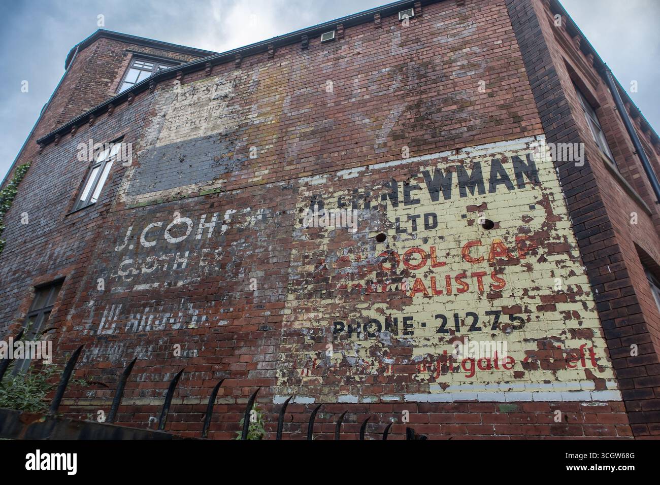 Weathered ghost sign on the side of a red brick building showing ...