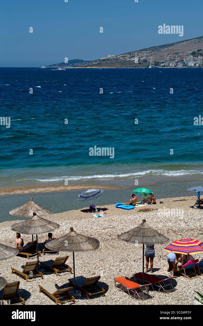 Vista della spiaggia con turisti e del mare con la città di saranda ...