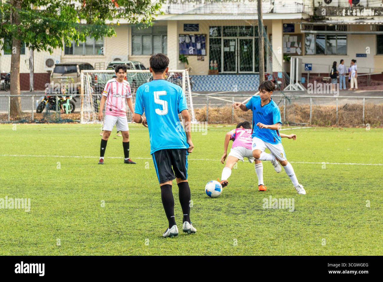 A view of two football players fighting for the ball while the referee ...