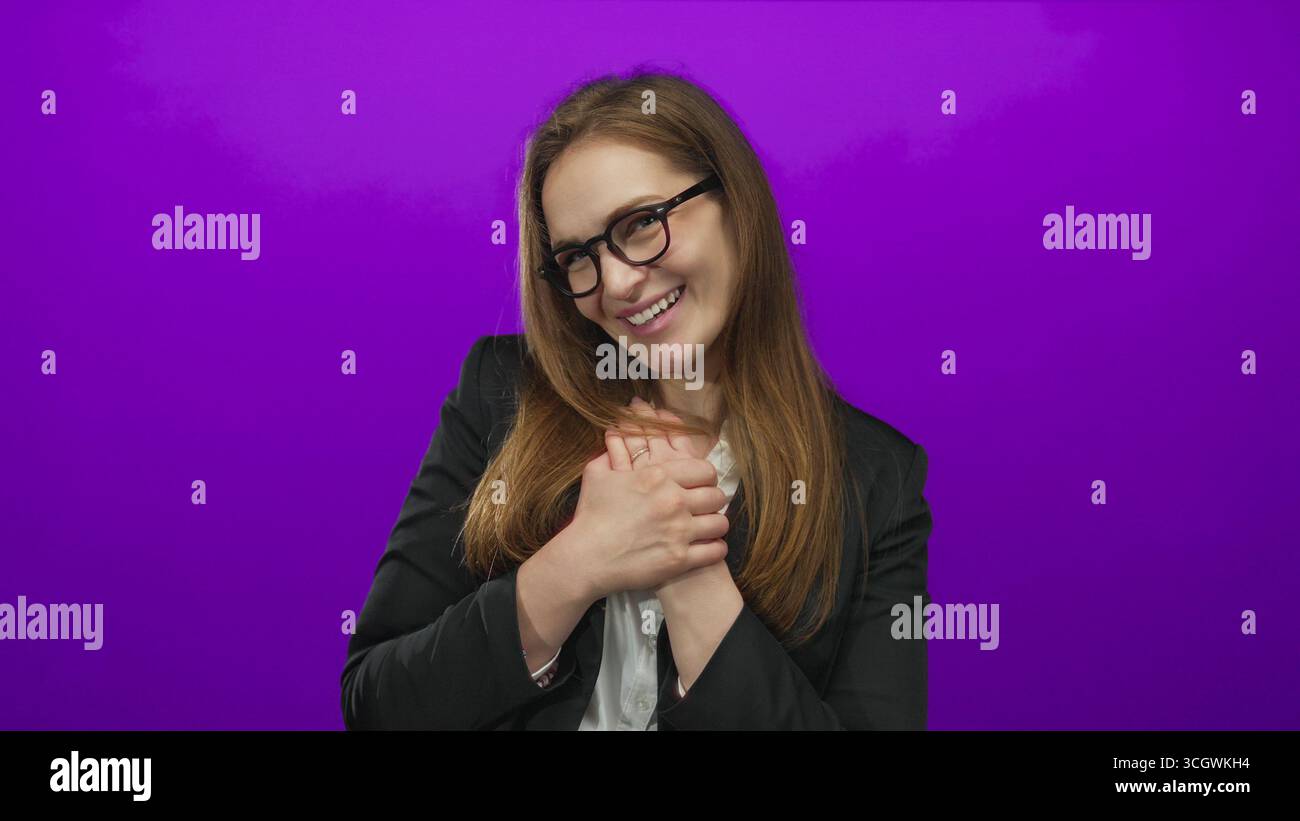 Woman in black blazer and white shirt clutch chest and wince in purple ...