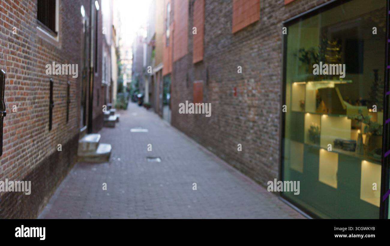 Blurred image of a narrow european alley with brick buildings and a ...