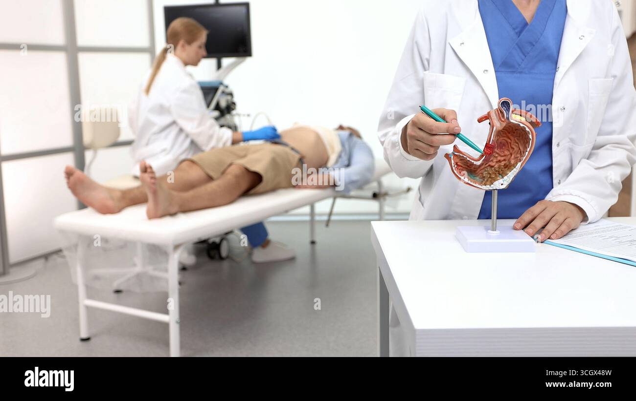 Ultrasound specialist doing ultrasonography of abdominal cavity for ...